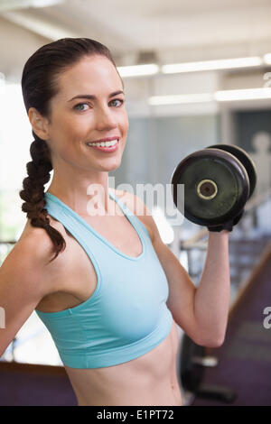 Smiling woman lifting heavy dumbbells Stock Photo - Alamy