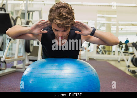 Fit man balancing on exercise ball Stock Photo - Alamy