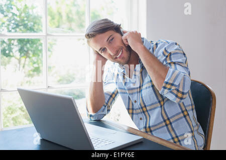 Handsome man sitting at table talking on phone Stock Photo - Alamy
