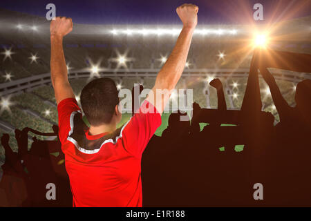 Composite image of excited football player cheering holding algeria ...