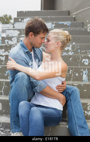 Young couple embracing on steps Stock Photo - Alamy