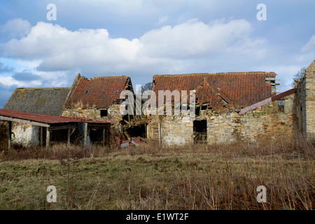 Derelict abandoned farm buildings with broken windows and barrier by ...
