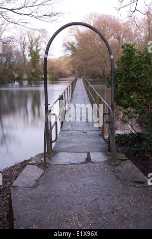 The ford at Moreton in winter. A long pedestrian bridge spans this ...