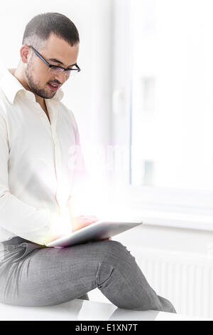 Businessman with tablet PC using virtual screen with abbreviation DE ...