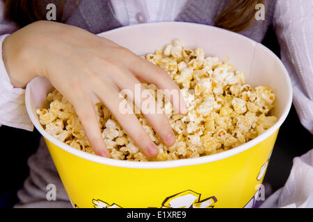 hand in a bucket of popcorn Stock Photo - Alamy