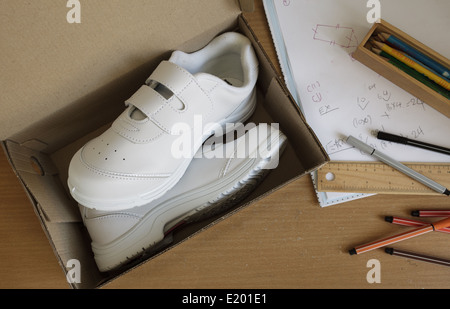 Cardboard box with white sneakers on green background Stock Photo - Alamy