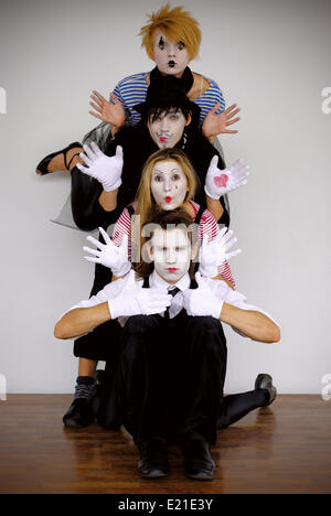 Mime male in red hat and in vest pointing with his hand to up on blank ...