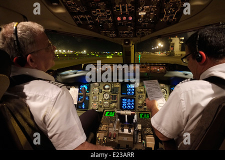 Pilot and first officer reviewing a pre-flight checklist in the cockpit ...