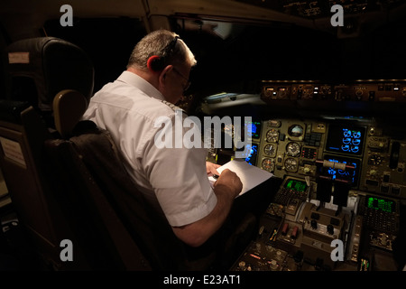 Pilot and first officer reviewing a pre-flight checklist in the cockpit ...