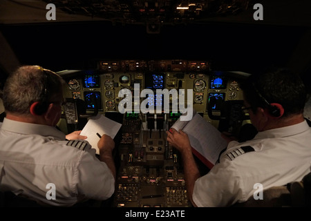 Pilot and first officer reviewing a pre-flight checklist in the cockpit ...