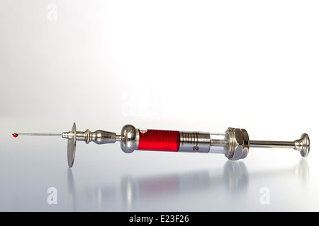 Vintage syringe with blood on reflecting underground Stock Photo - Alamy