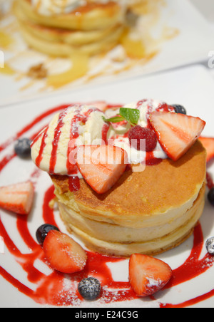 Close-up of pancakes and fruits served in plate on table Stock Photo ...