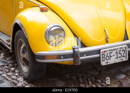 A pretty street scene with yellow vw bug on a steep street in Cusco ...