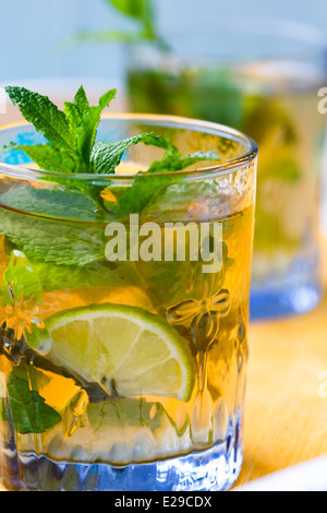 Tea with lemon and mint in nature. A cup of hot mint tea with lemon and ...