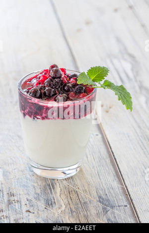 Yoghurt with red Berries in a glass on a wooden table Stock Photo - Alamy