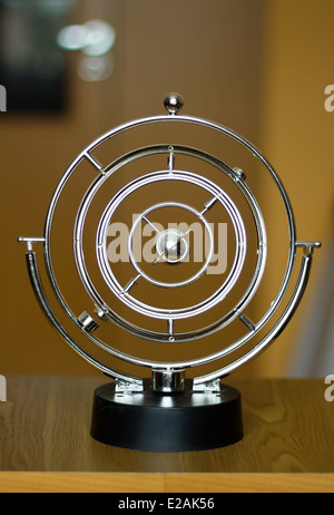 Modern pendulum on table in office Stock Photo - Alamy