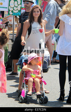 Ariel Winter takes a break to sit down in a stroller, as she enjoys a ...