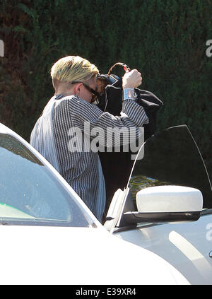 Miley Cyrus hides her face with a heart shaped Chanel handbag as she ...