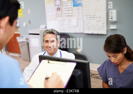 Medical Staff Meeting At Nurses Station Stock Photo - Alamy