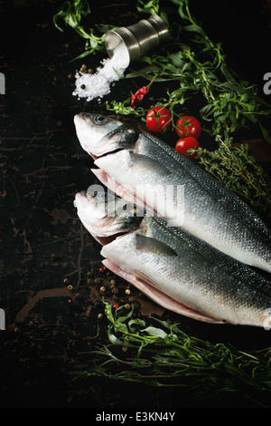 Raw sea bass or seabass fish in a baking dish. White background. Top ...