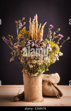 Wildflowers in the bagging vase on a table Stock Photo - Alamy