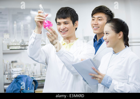 University students doing experiment on microscope in laboratory at ...