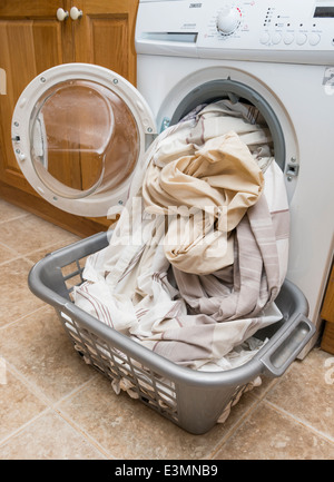 Washing machine and basket with dirty clothes in laundry room Stock ...