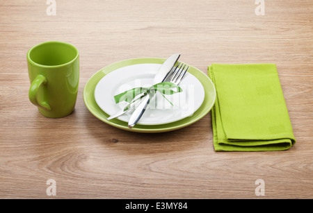 Kitchen utensils, plates, silverware over wooden table with copyspace ...