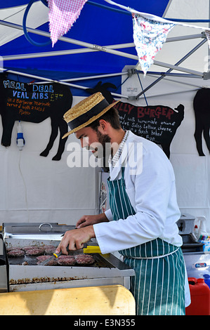 Chef preparing beef burgers on grill at outdoor fast food stall, Derry ...