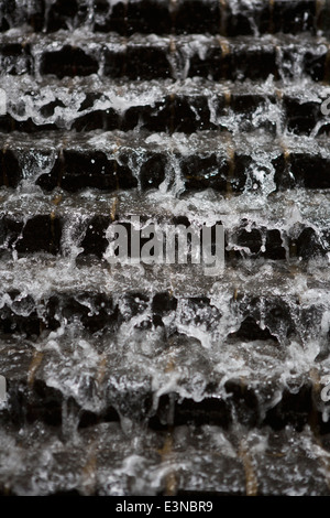 A vertical shot of water flowing through rocks at Mount Esja Iceland ...