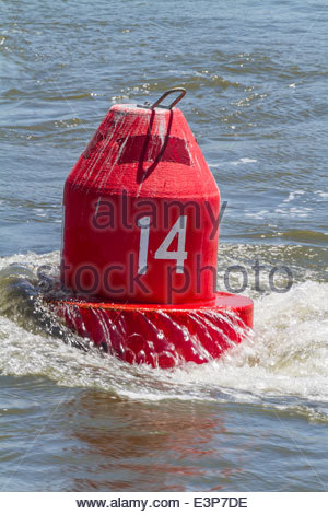 A red buoy is floating on the water surface in the Port of Rotterdam in ...