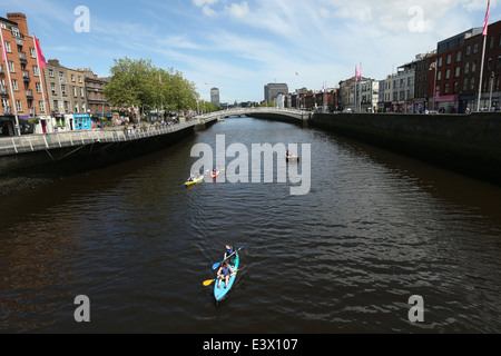 People kayak on the river Liffey towards the Ha'Penny bridge in Dublin ...