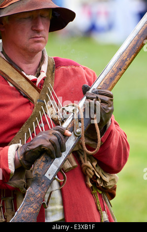 17th century Civil War Musketeer aiming his matchlock musket. Played by ...