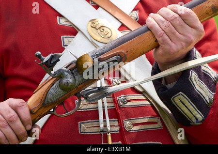 Actor in British Redcoat uniform holding a 'Brown Bess' flintlock ...