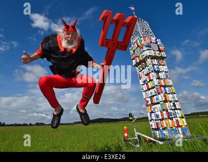 Tour devil Dieter (Didi) Senft sits in front of a billboard with a ...