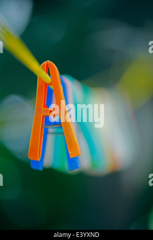 Colorful clothes pegs hanging in wire Stock Photo - Alamy