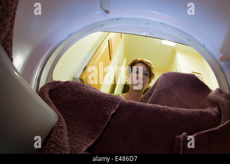 Woman removing towels from dryer Stock Photo - Alamy