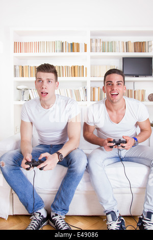 Two Brothers or Friends Playing Video Games Together as They Relax on a ...