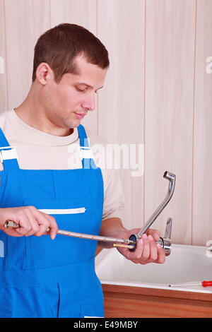Portrait of plumber fitting tap Stock Photo - Alamy