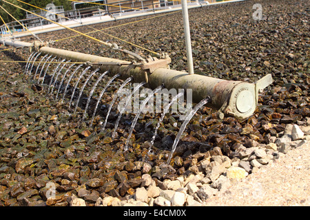 Sewage treatment plant works the rotating arm pours sewage over the ...
