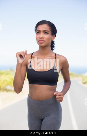 Fit woman running along the open road Stock Photo - Alamy