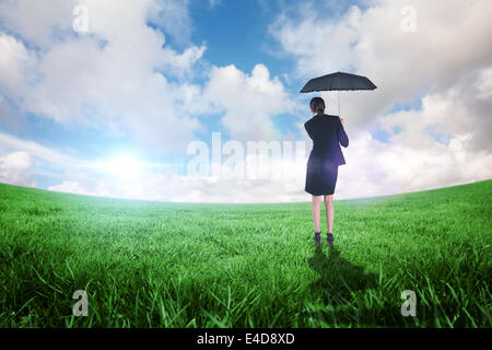 Composite image of young businesswoman holding umbrella Stock Photo - Alamy