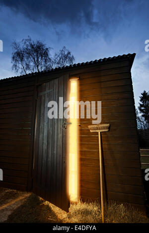 Light spilling from an open workshop door Stock Photo - Alamy