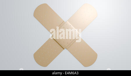 Two regular sticky plasters criss crossed on an isolated white studio ...