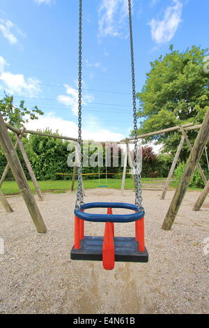 Playground with a blue and red slide and a red swing set. The ...