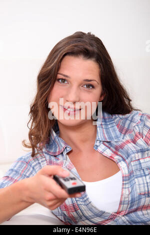 Close-up Of A Woman Changing The Channel With Remote Control While ...