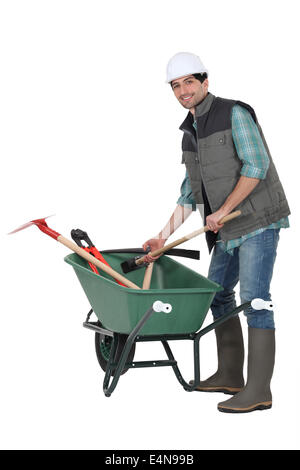 Mason pushing wheelbarrow Stock Photo - Alamy