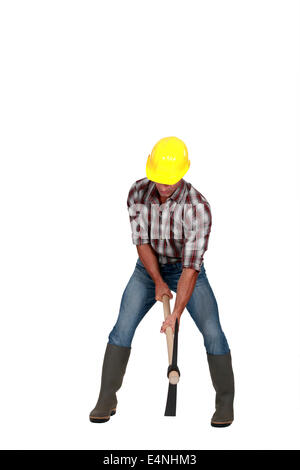 Worker using a pickaxe Stock Photo - Alamy