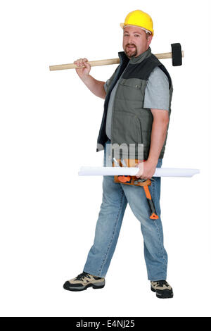 Construction worker holding a sledge hammer standing on demolish ...