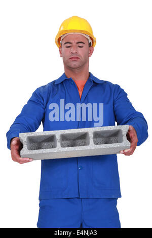 Man carrying heavy brick Stock Photo - Alamy